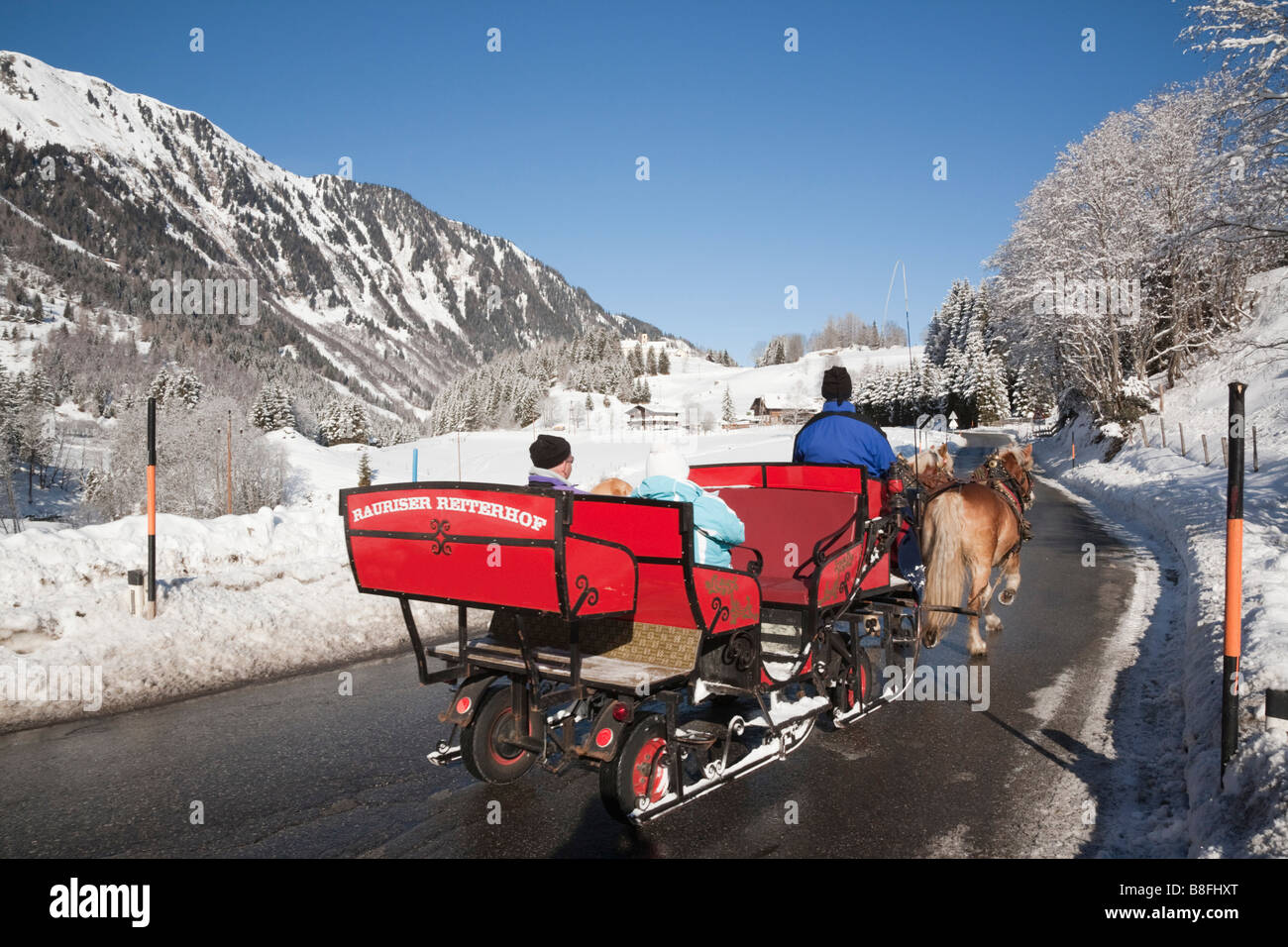 Tourists on horse drawn sleigh ride through Alpine valley in winter ...