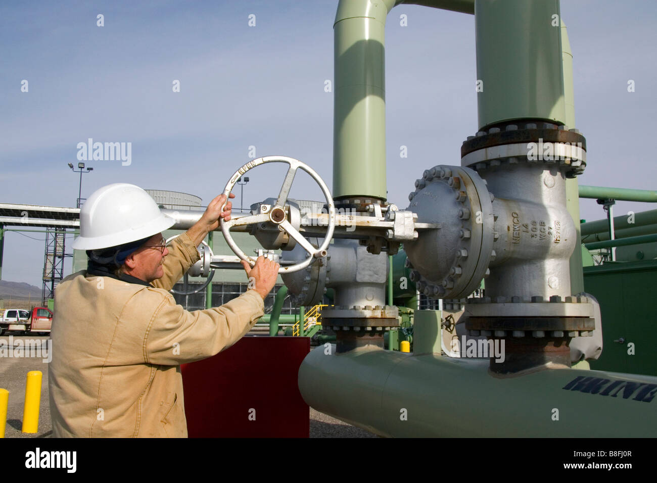 Operator turning a valve at a geothermal power plant in Malta Idaho USA ...