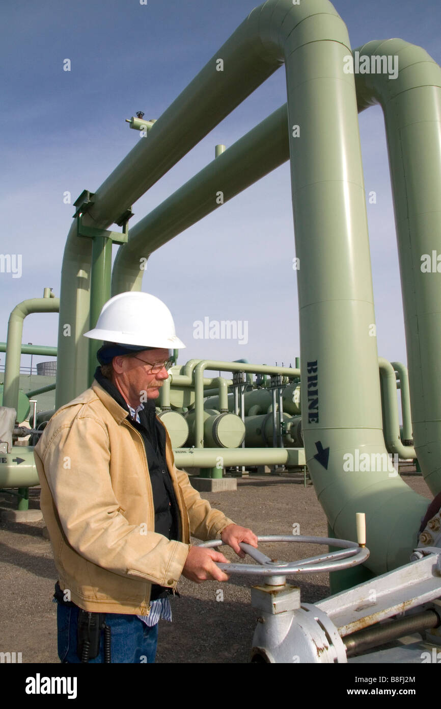 Operator turning a valve at a geothermal power plant in Malta Idaho USA ...
