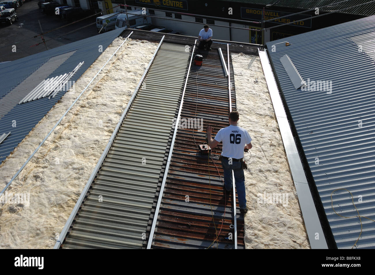 Contractors lay extra Insulation on roof of an industrial unit building ...