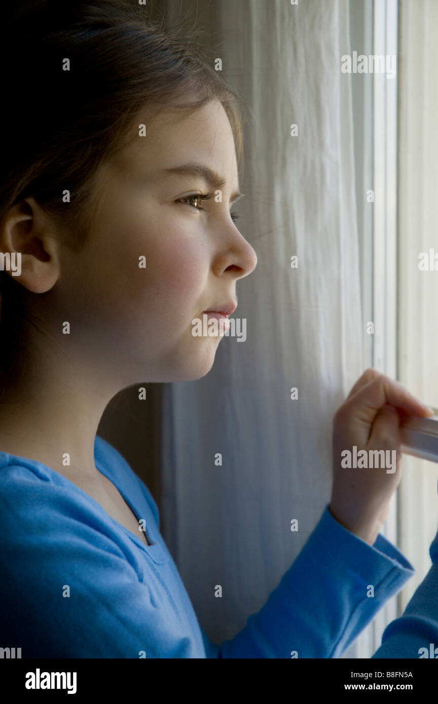 Young female looking out window Stock Photo - Alamy