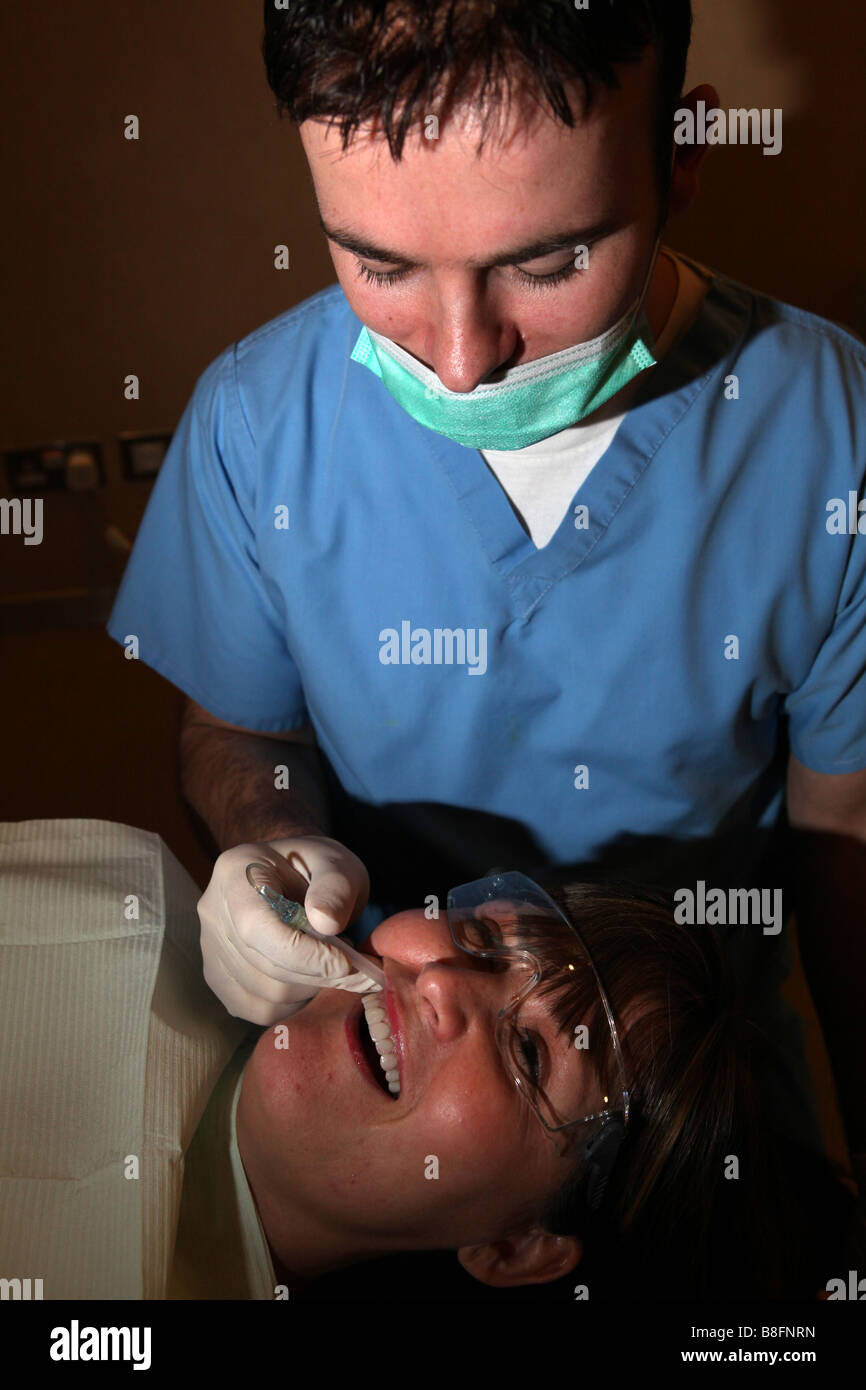 a dentist uses the magic wand pain relief devise on a patient prior to ...