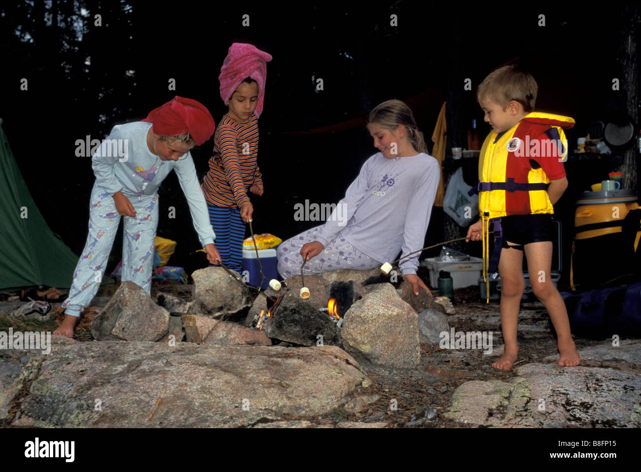 Family and children round campfire Stock Photo - Alamy