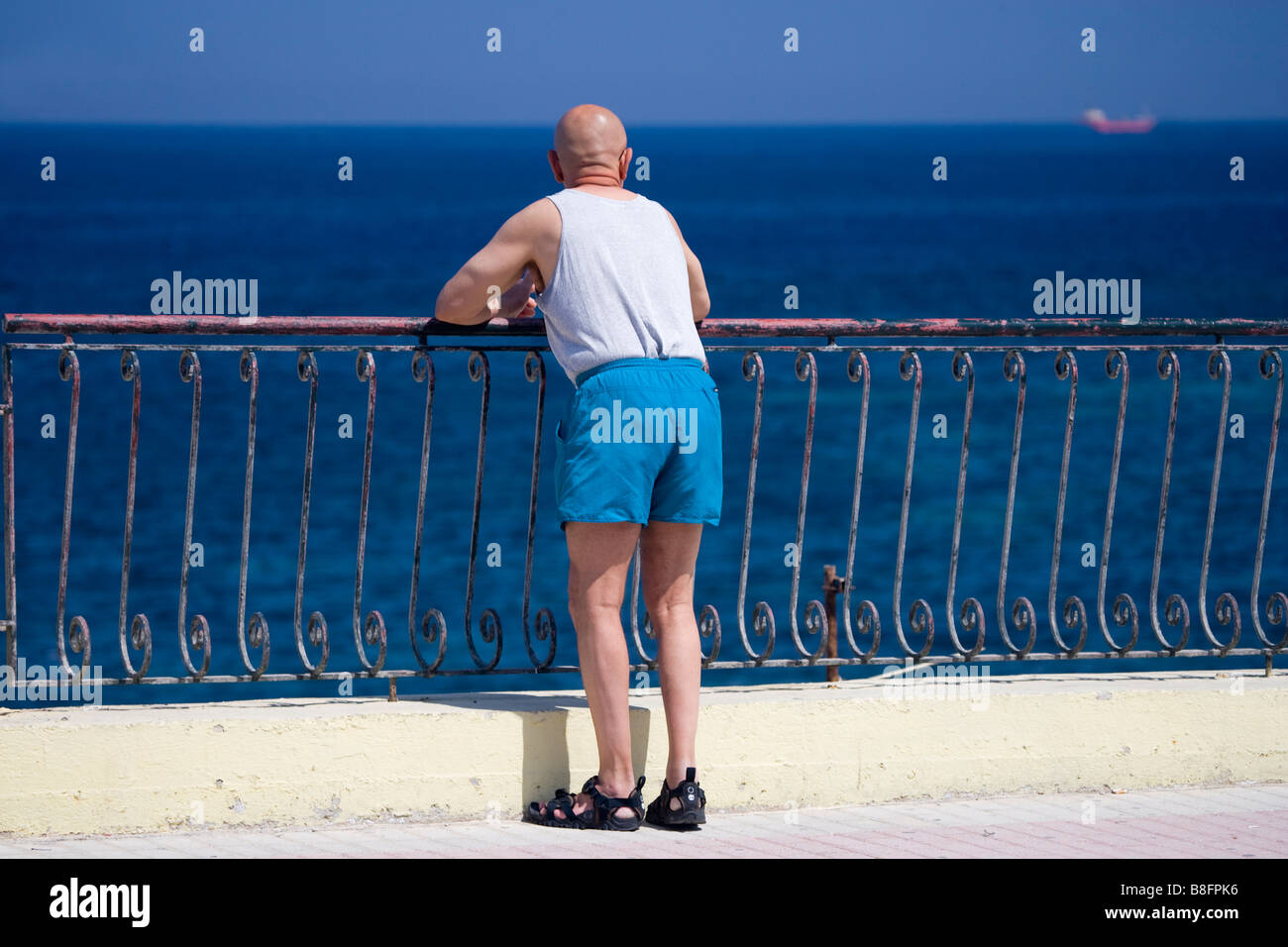 Old man in vest and shorts looking out to sea Bugibba Malta Stock Photo ...