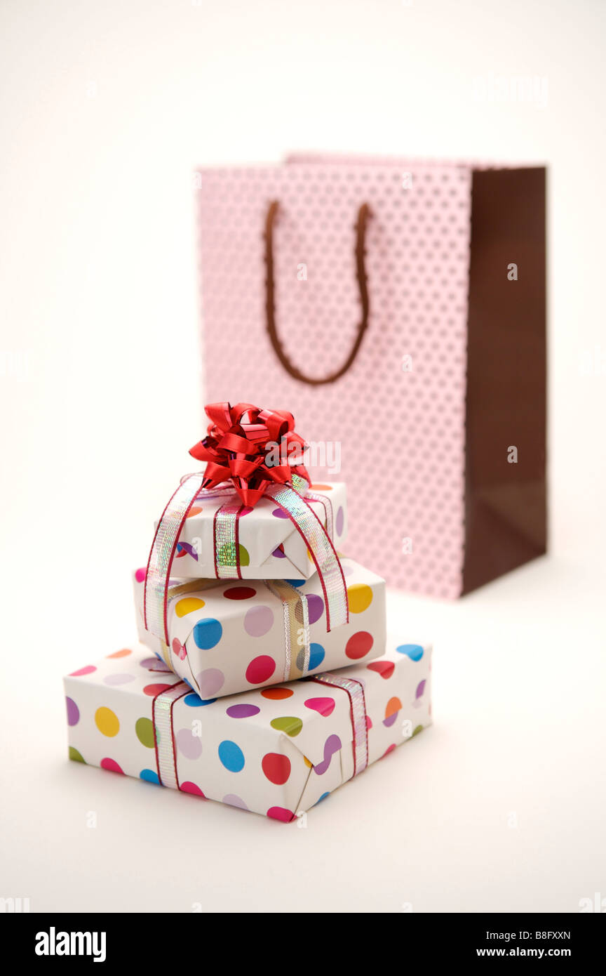 Three wrapped gifts and a shopping bag Stock Photo - Alamy