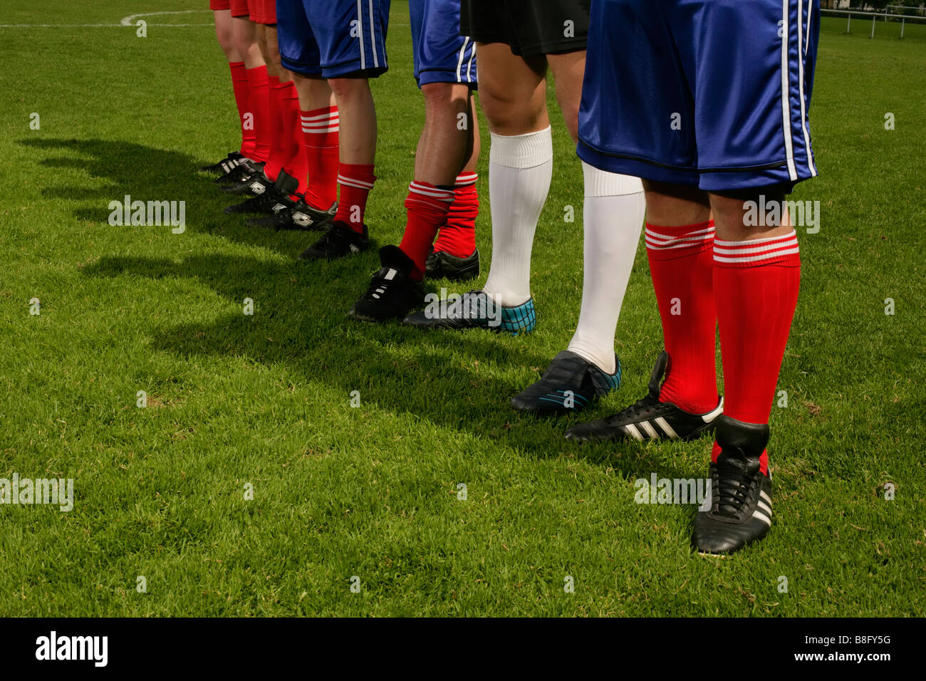 Six footballers in sports wear standing next to each other on a pitch ...