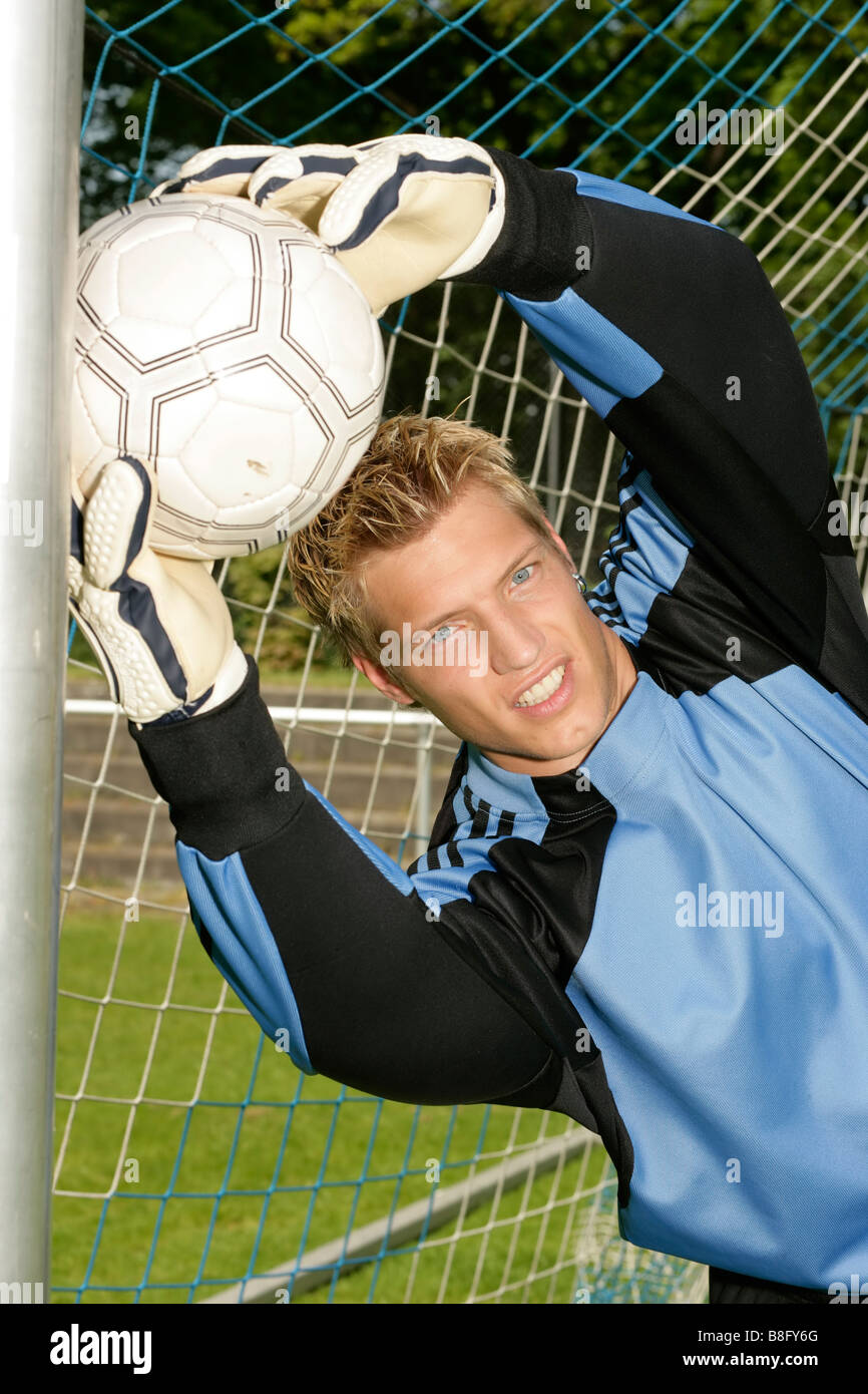 Young goalkeeper holding a football, close-up Stock Photo - Alamy