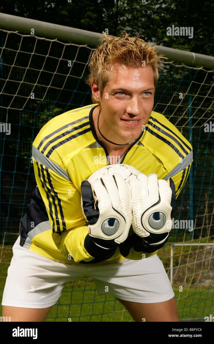 Young goalkeeper holding a football, close-up Stock Photo - Alamy