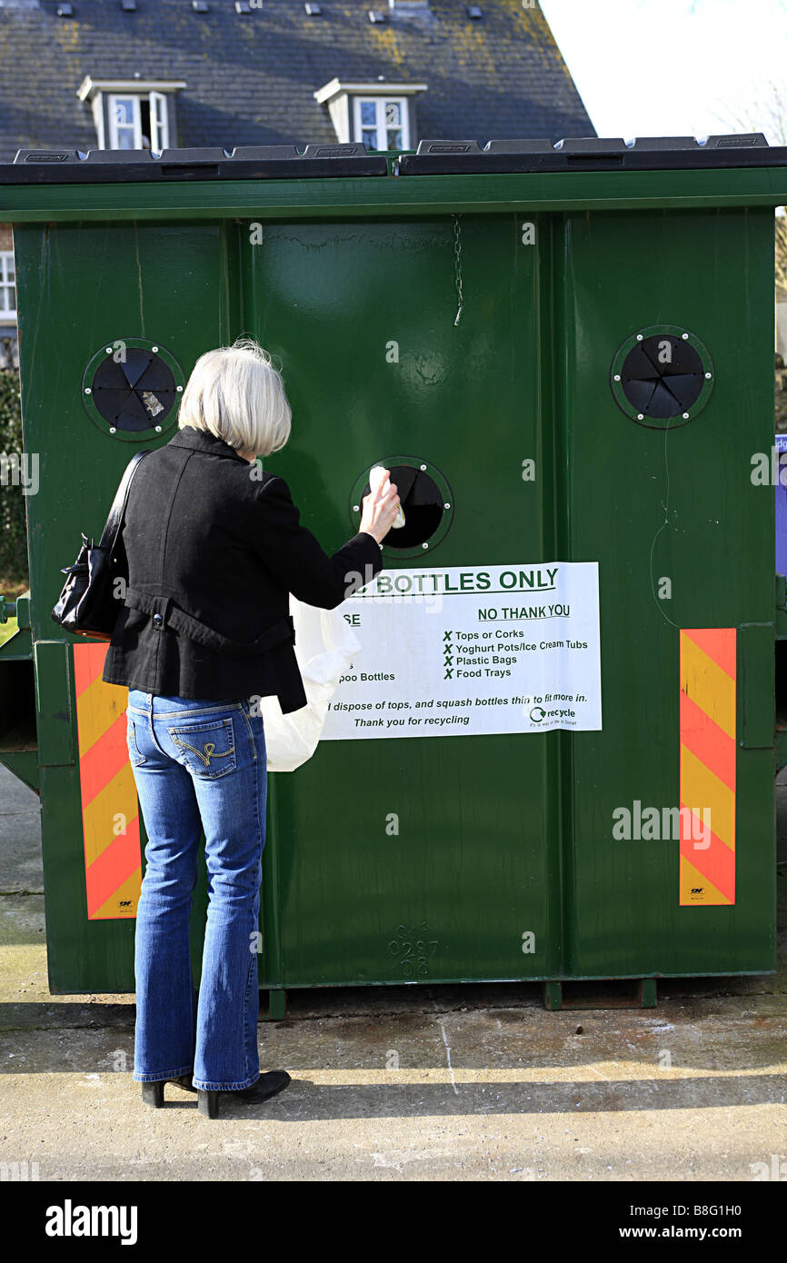 An adult female placing plastics from a carrier bag into a recycling ...