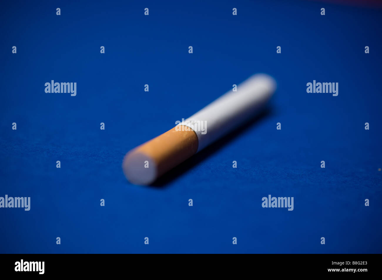 A cigarette on a blue background Stock Photo - Alamy