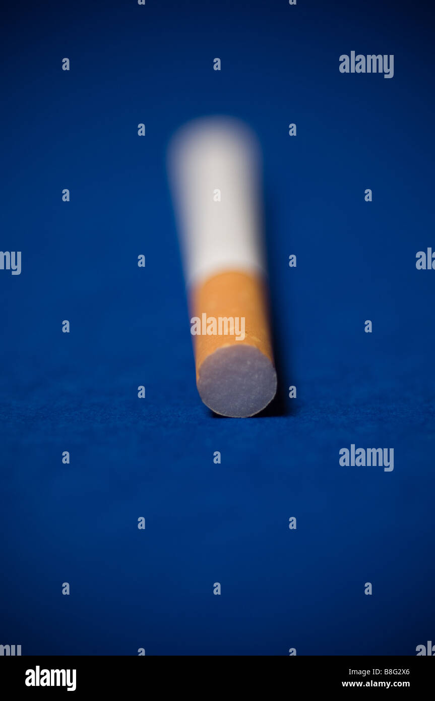 A cigarette on a blue background Stock Photo - Alamy