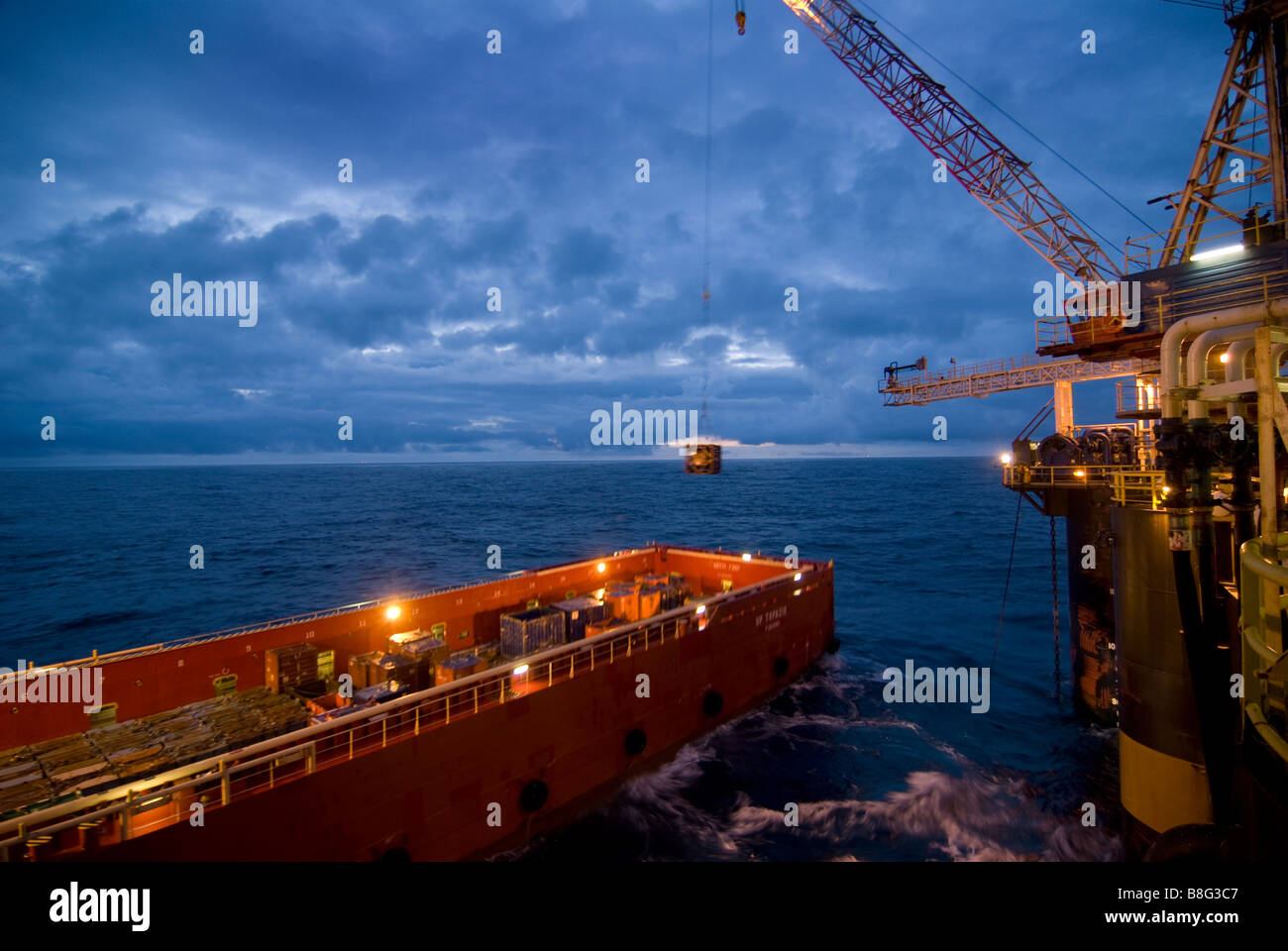 photograph of drilling platform crane lowering container onto supply ...