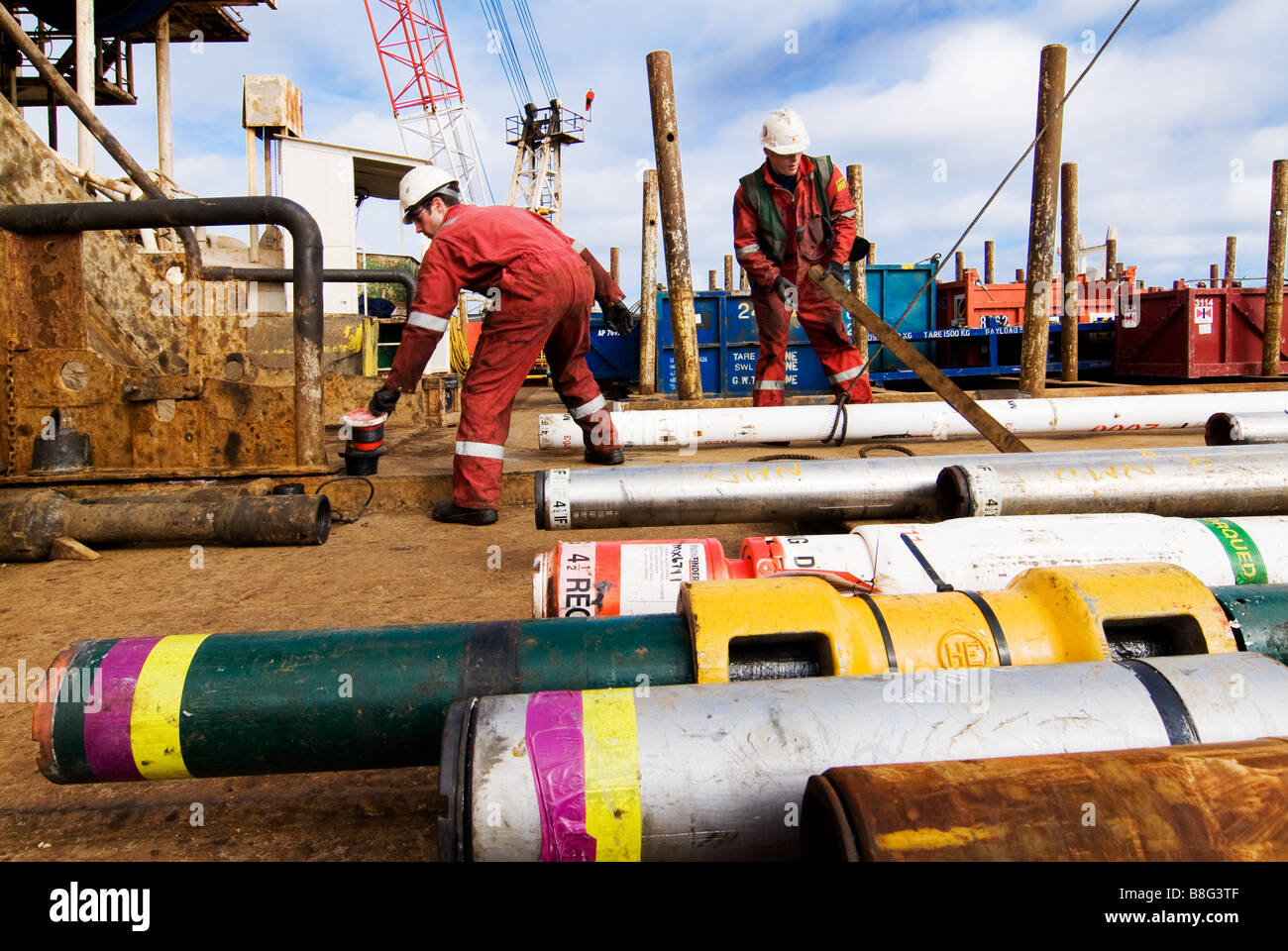 photograph of workers on oil rig drill deck prepapring pipes Stock ...