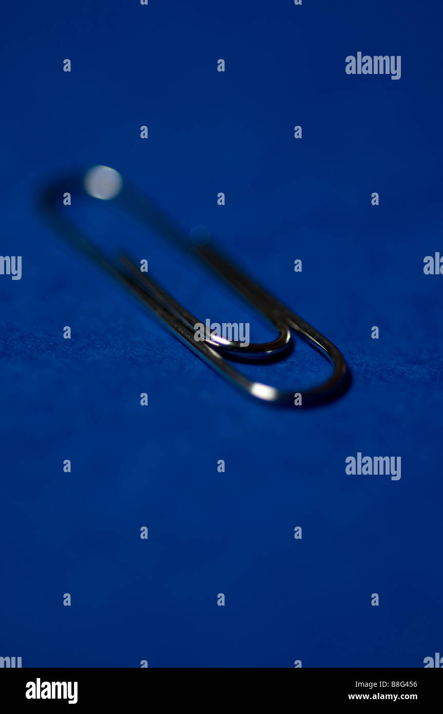 An office paper clip on a blue background Stock Photo - Alamy