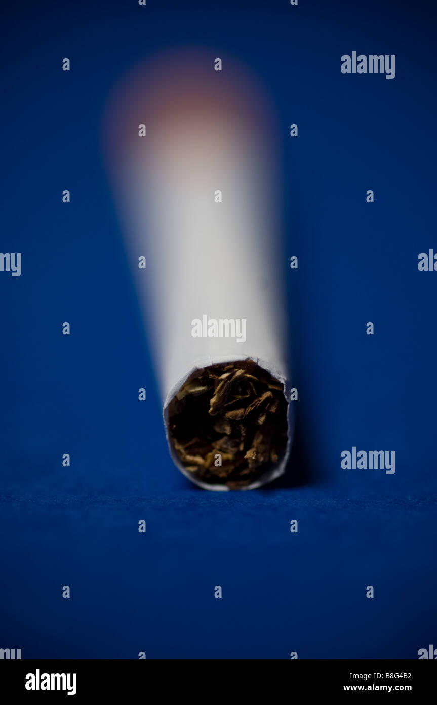 A cigarette on a blue background Stock Photo - Alamy