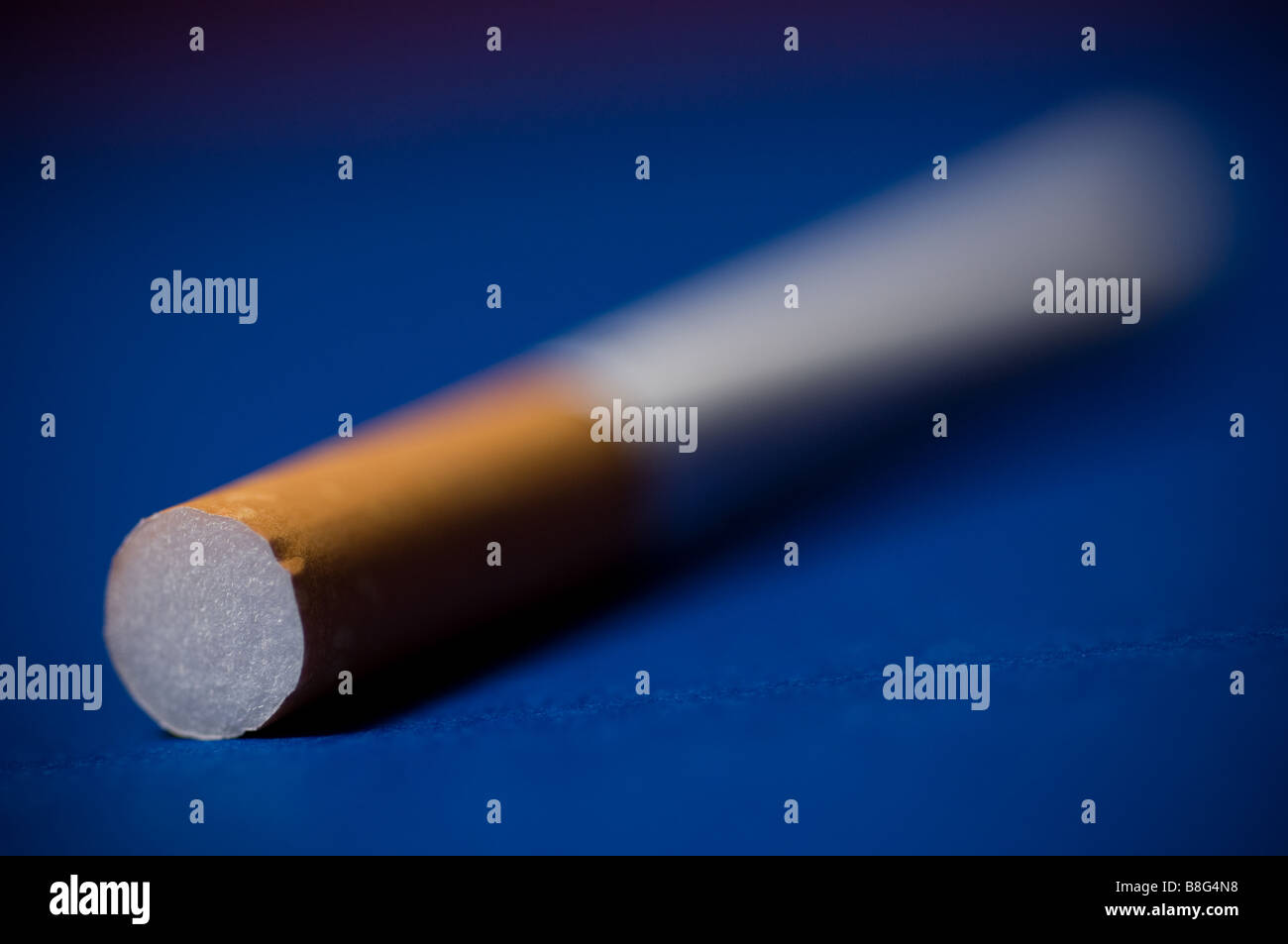A cigarette on a blue background Stock Photo - Alamy