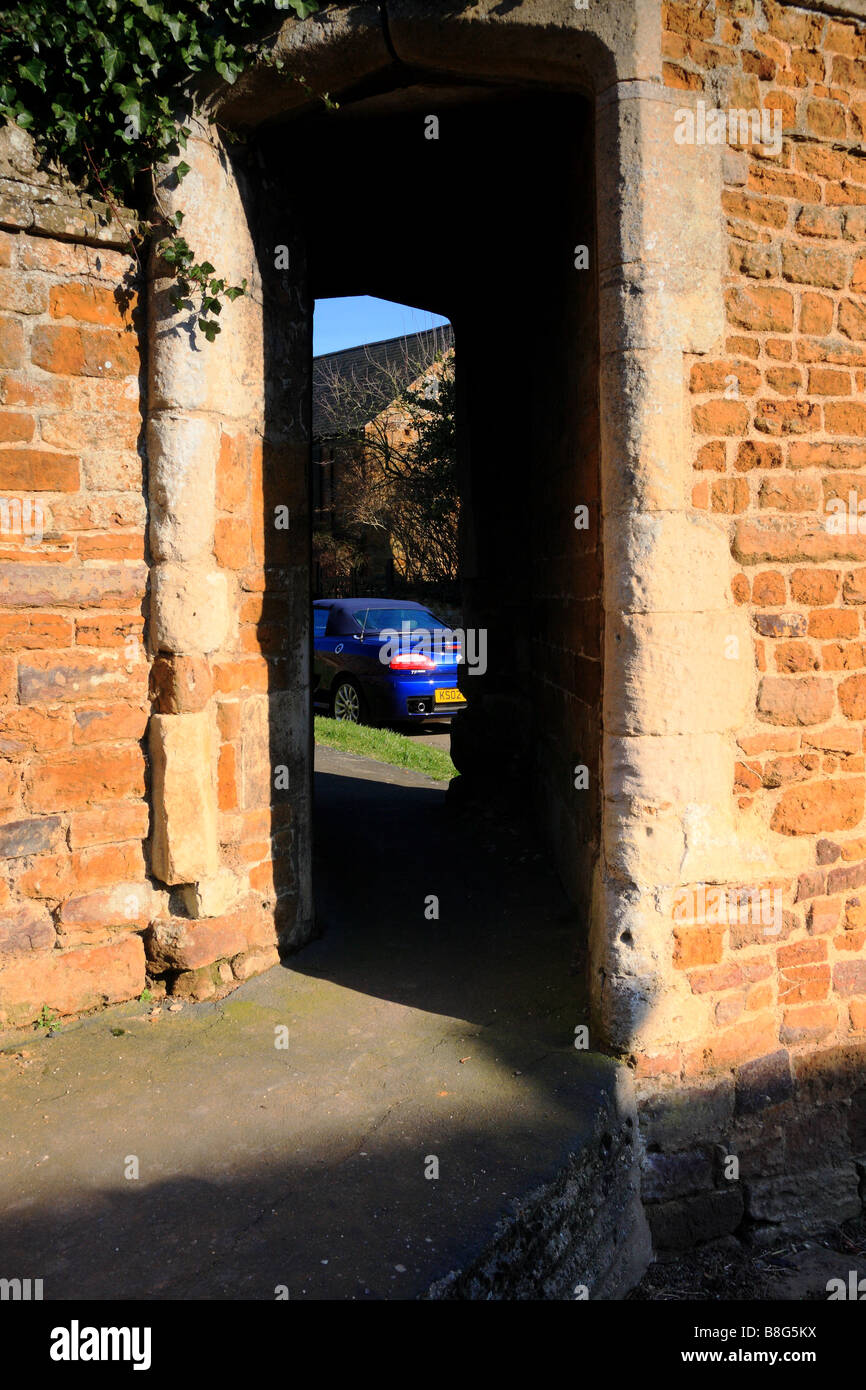 A blue MG is visible througha narrow passageway Stock Photo - Alamy
