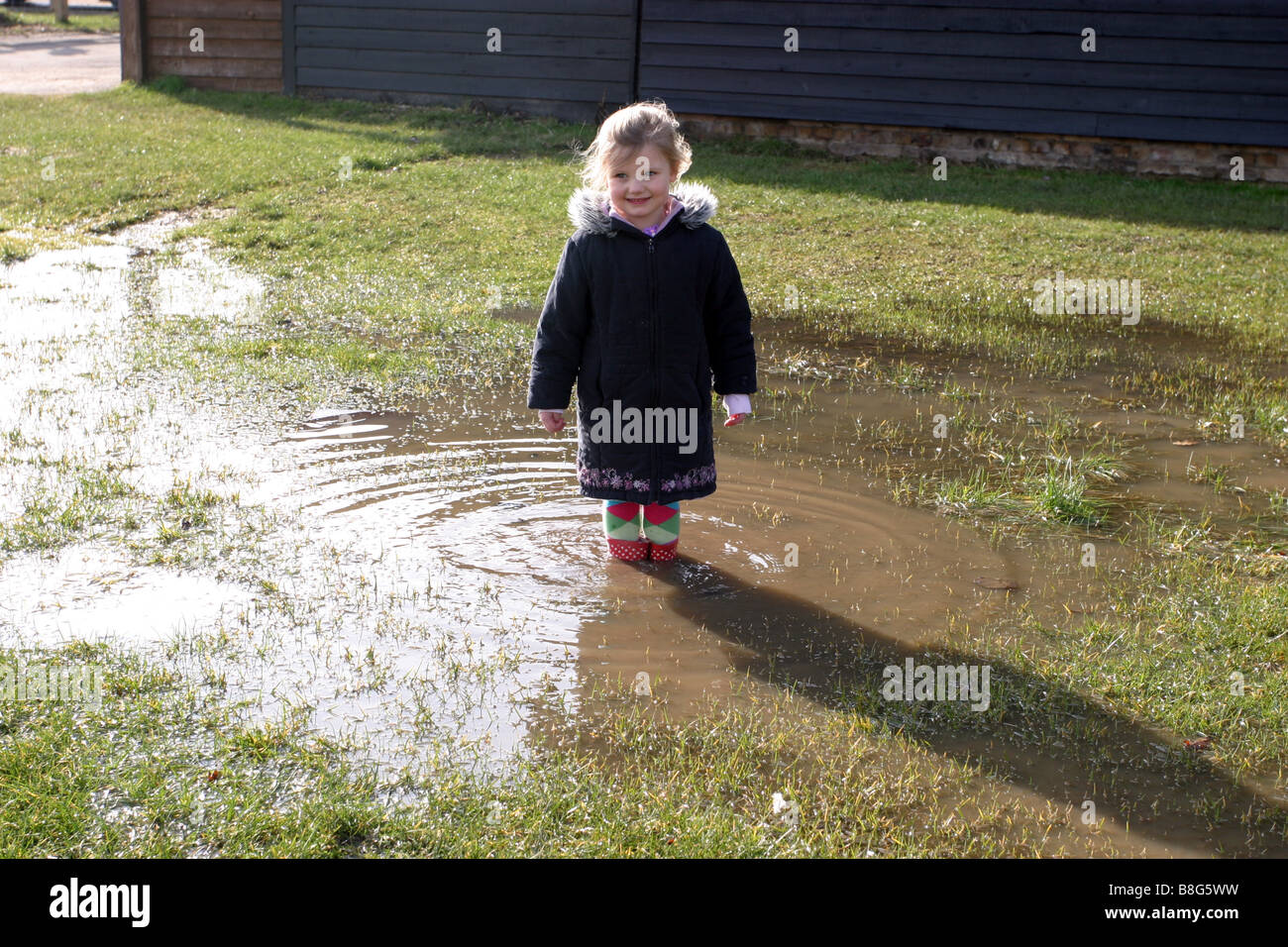 Girl standing in big puddle Stock Photo - Alamy