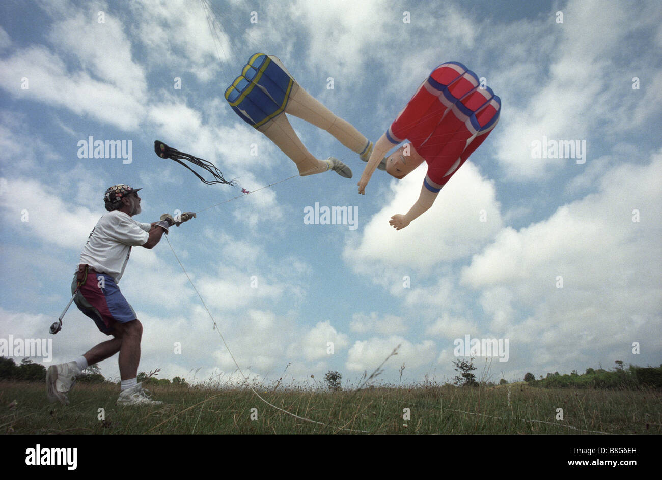 Man flying an unusual kite - two kites actually, one a torso and arms ...
