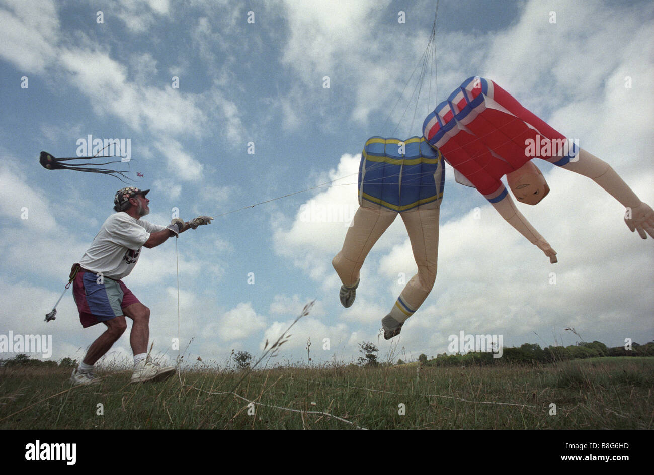 Man flying an unusual kite - two kites actually, one a torso and arms ...