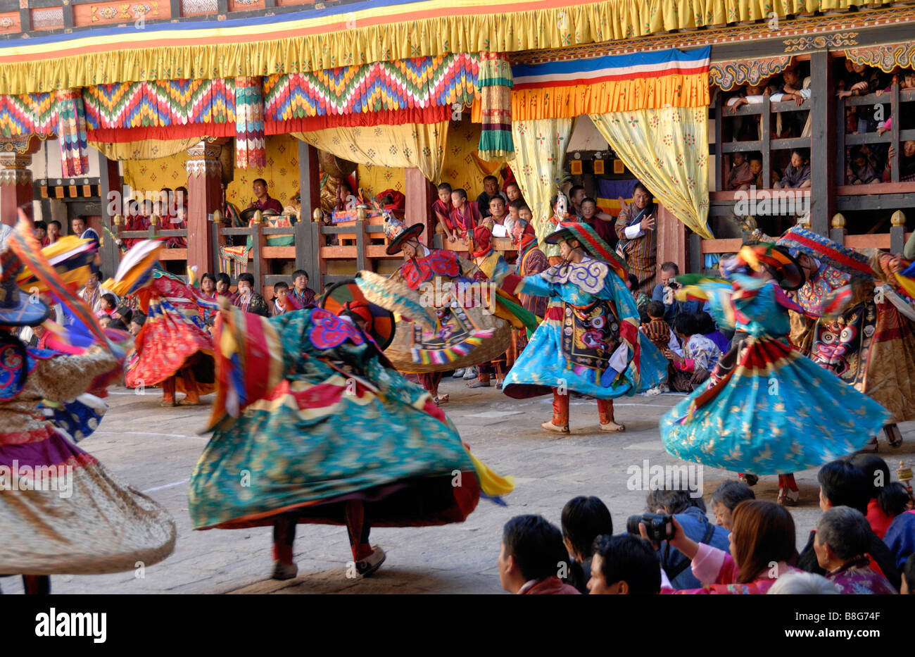 Musicians and young monks watch black hat dancers at the Trashigang ...