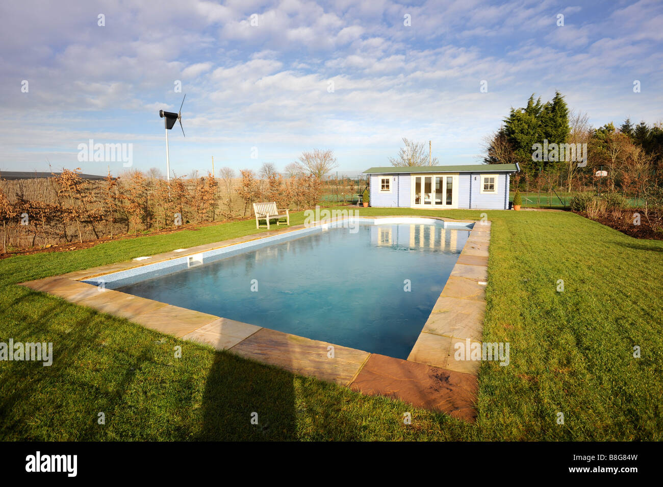 A SWIMMING POOL AT AN ENERGY EFFICIENT HOME WITH A WIND TURBINE AND ...
