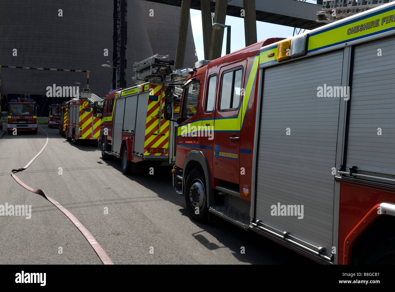 5 fire engines parked next to cooling towers at power station Stock ...