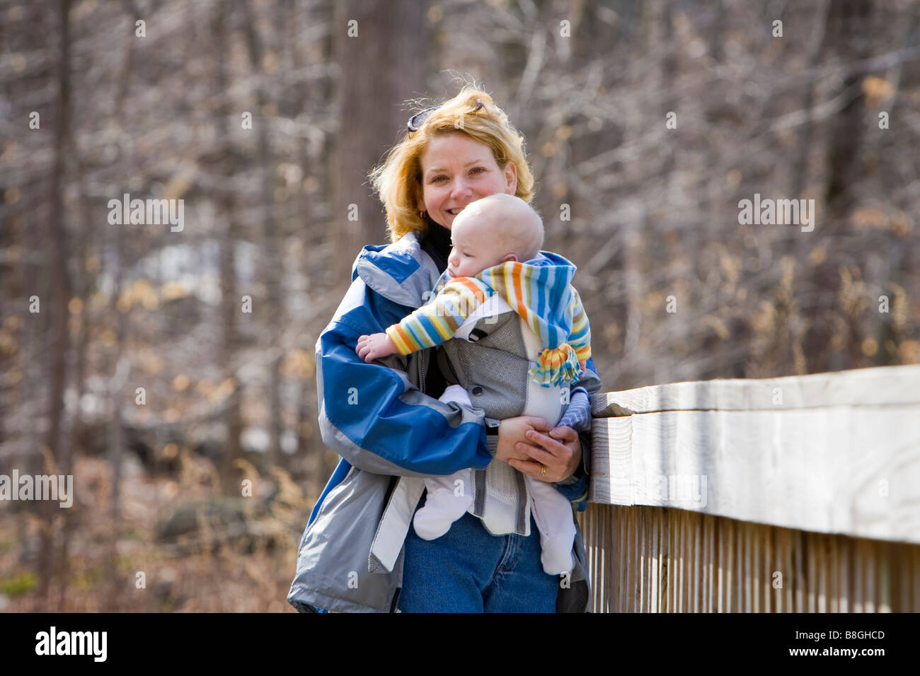 Thoughtful mother carrying baby on woodland walk Stock Photo - Alamy