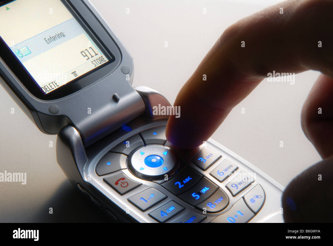 Modern personal cellular phone with fingers dialing 911 emergency ...