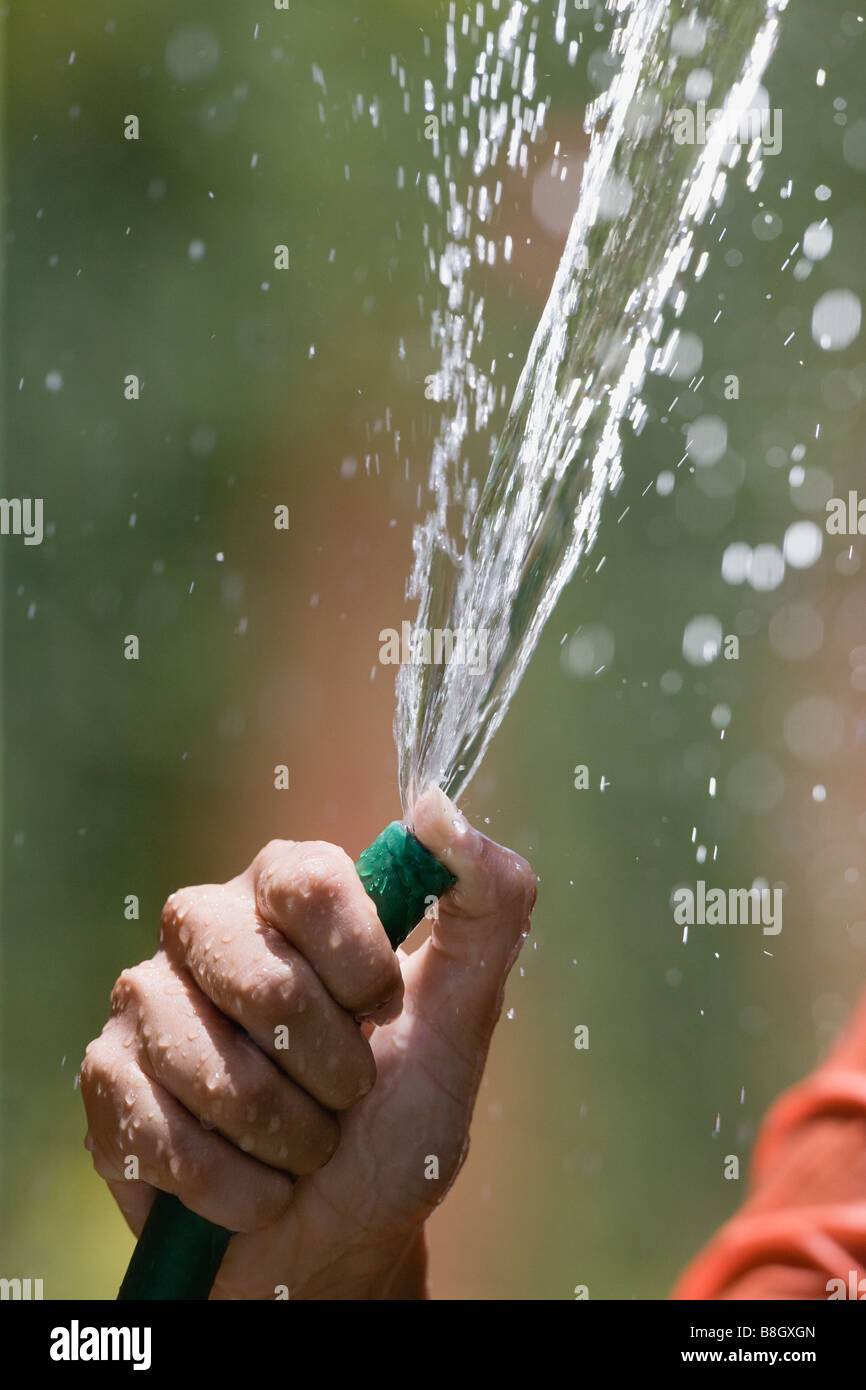 A woman's hand holding a water hose Stock Photo - Alamy