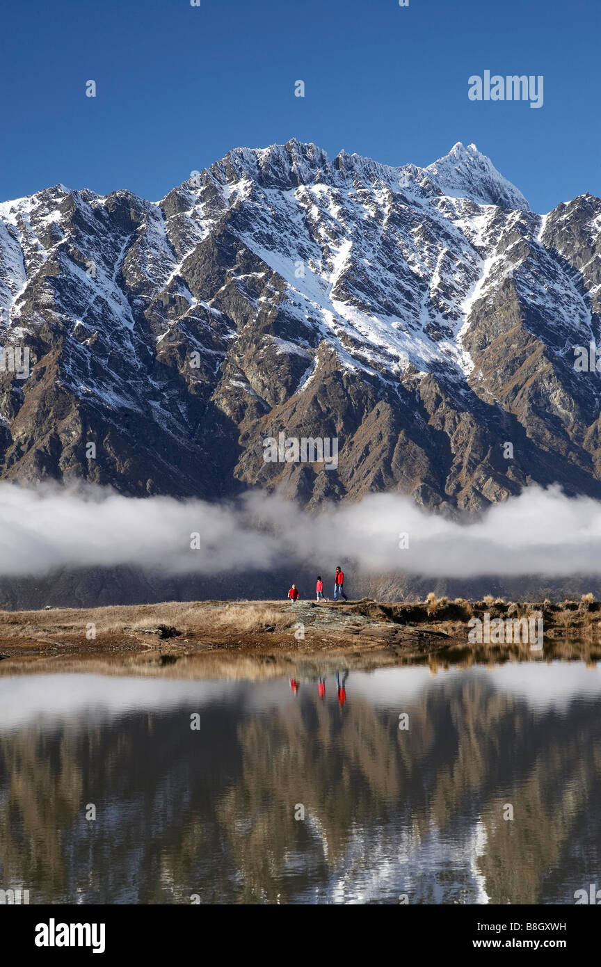 The Remarkables and Family Walking reflected in Summit Tarn Deer Park ...