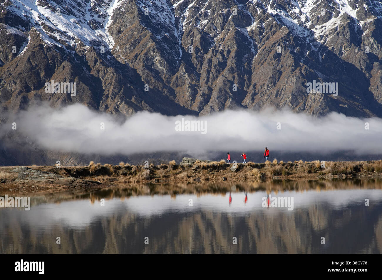 The Remarkables and Family Walking reflected in Summit Tarn Deer Park ...