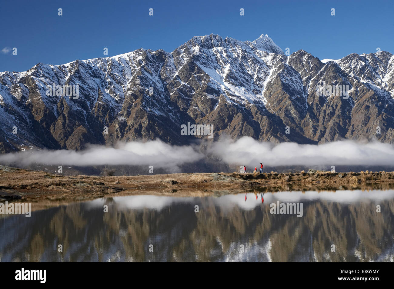 The Remarkables and Family Walking reflected in Summit Tarn Deer Park ...