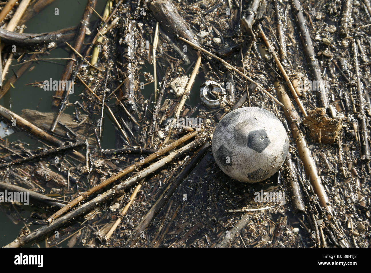 lots of rubbish garbage and ball floating in river in sun Stock Photo ...
