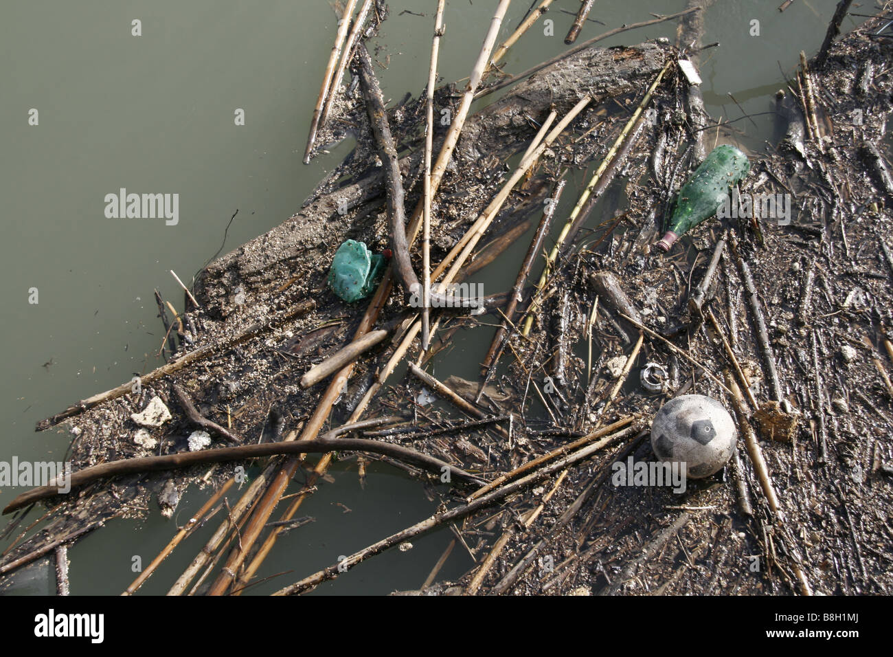 lots of rubbish garbage and ball floating in river in sun Stock Photo ...