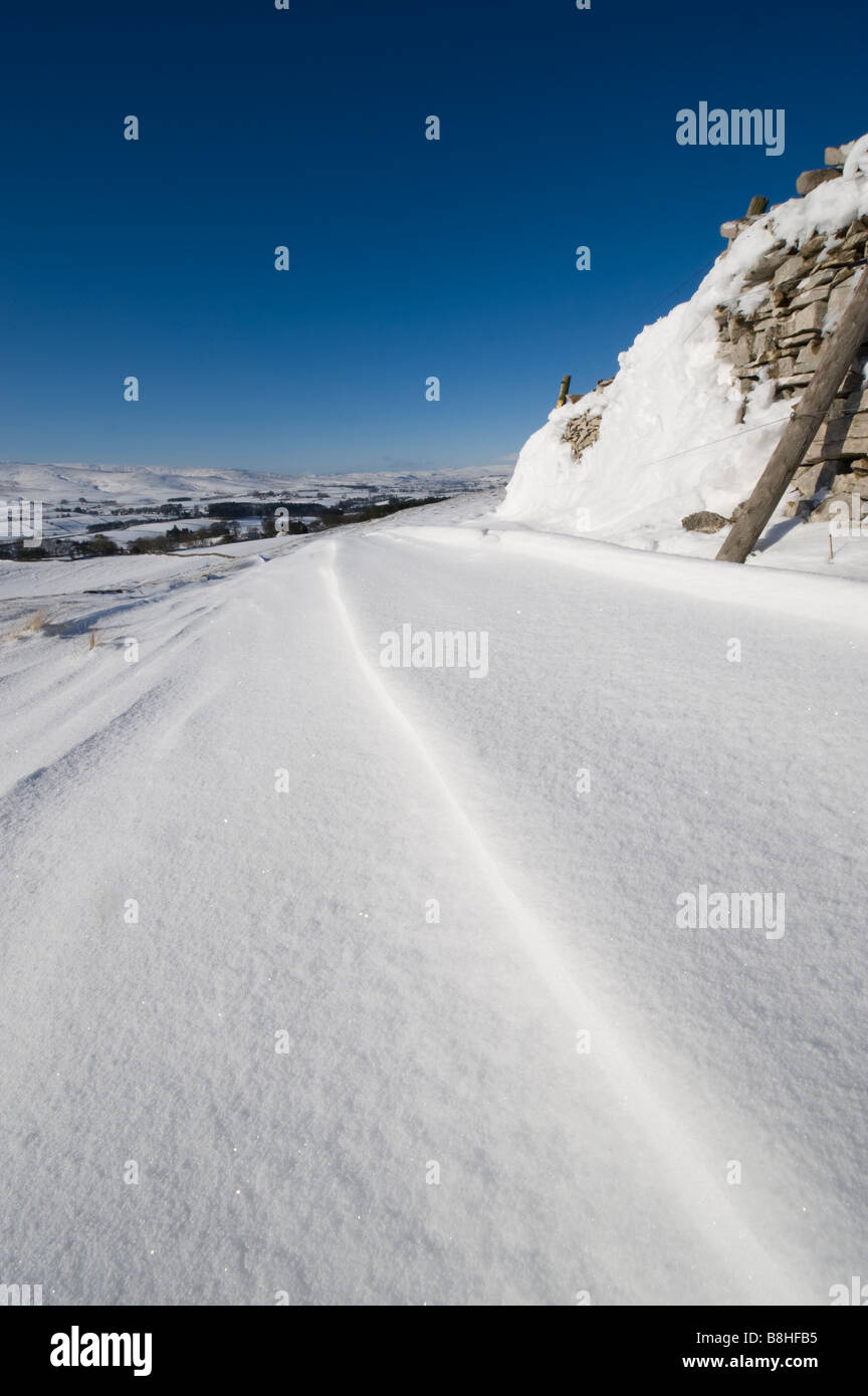 Snow drifts at the back of a drystone wall on uplands near ...