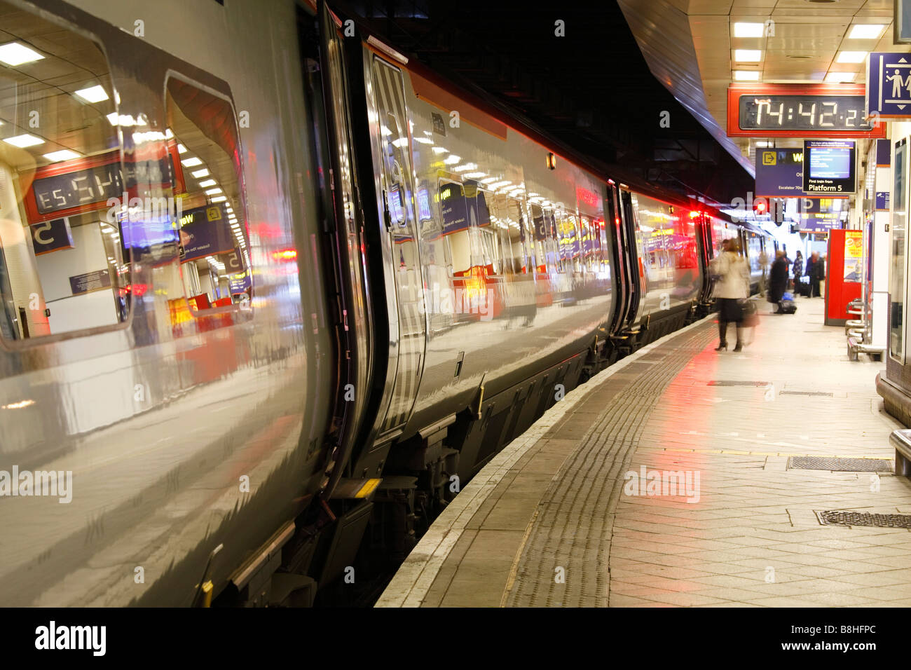 Train arriving at a platform at the train station Stock Photo - Alamy