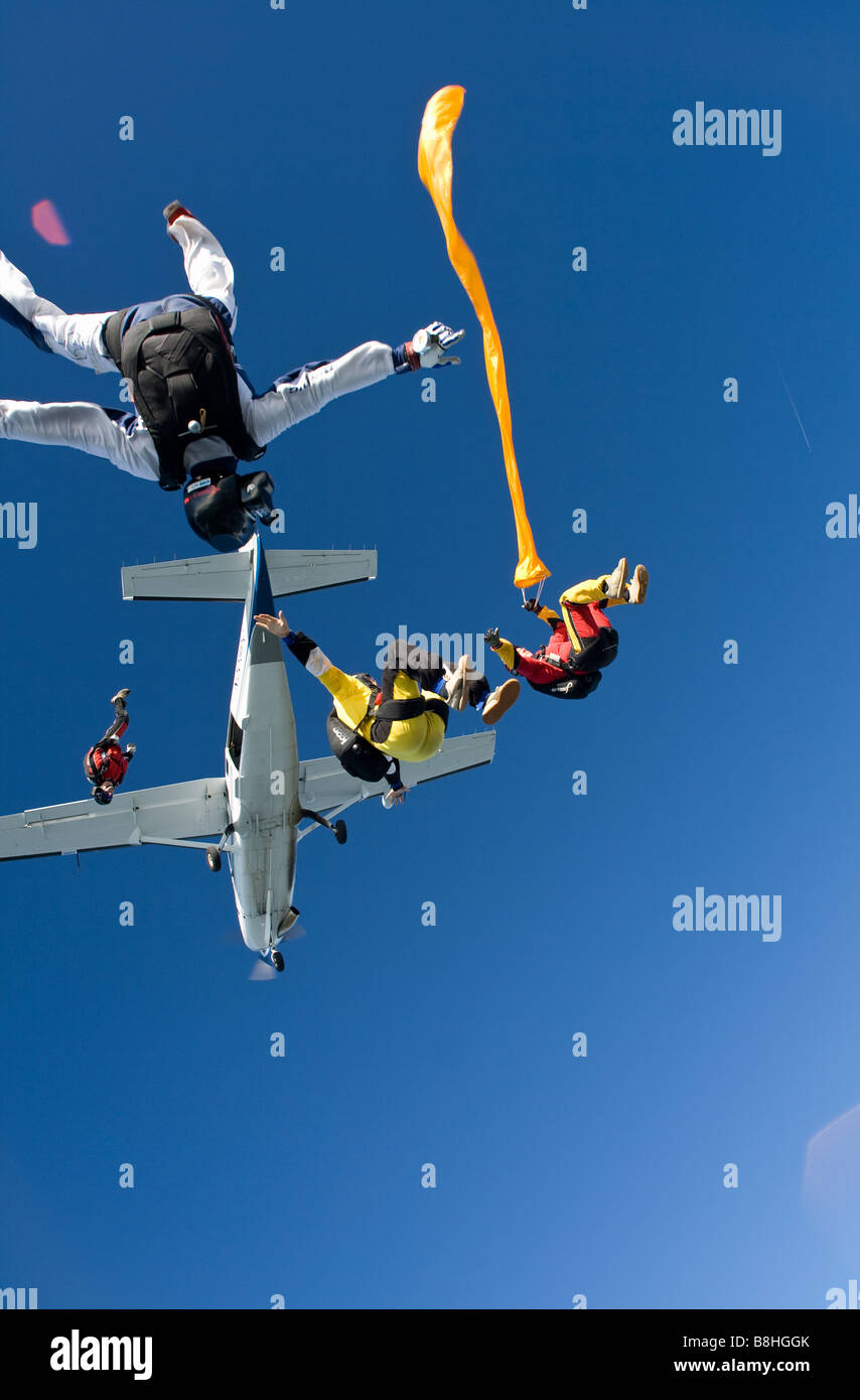 Skydivers are exiting a plane and holding a streamer. In this freefly ...