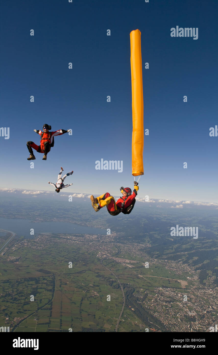 Skydive with orange tube jumper in between other fun divers. The ...