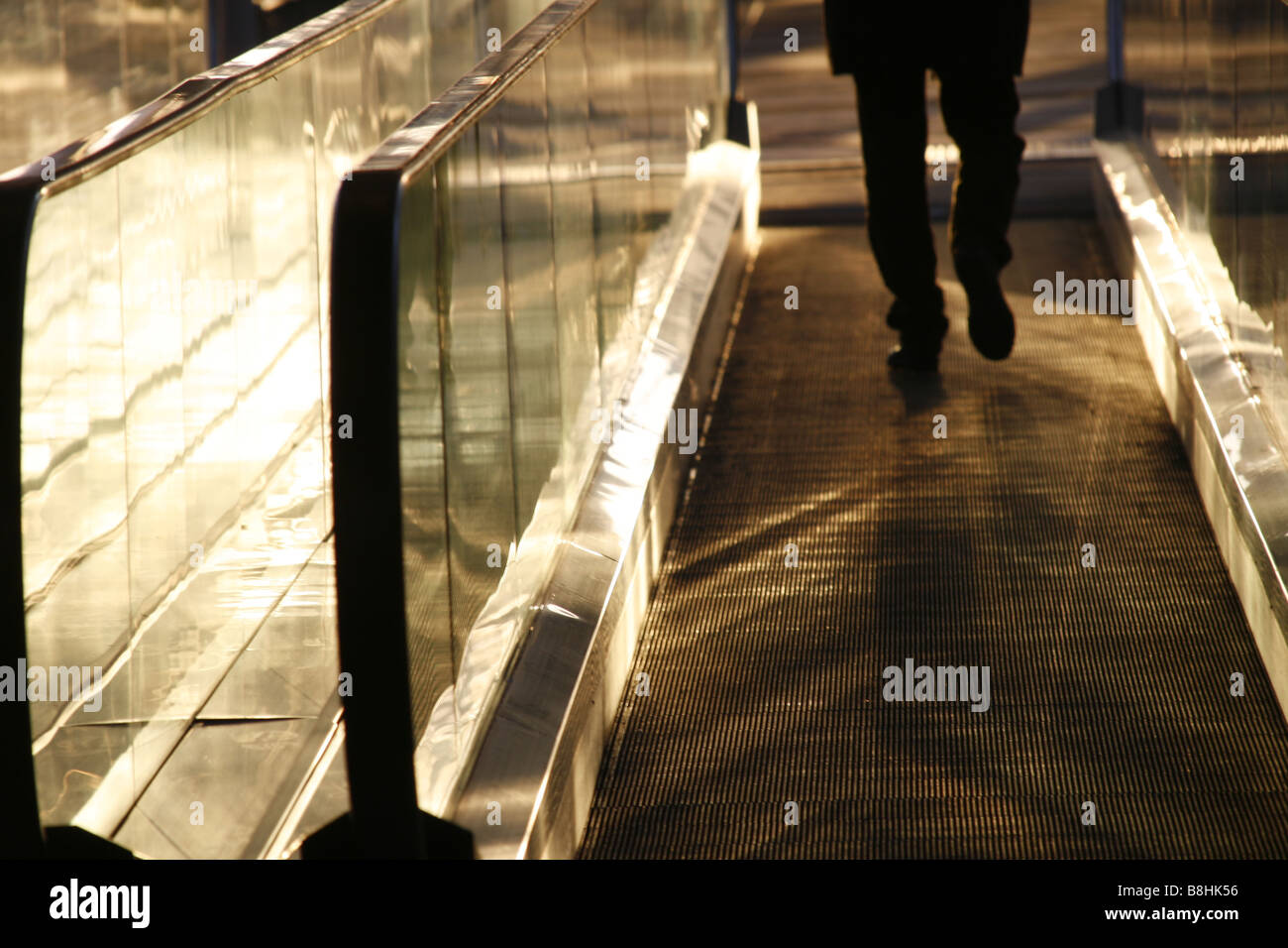 one person silhouette walking on escalator moving stairs Stock Photo ...