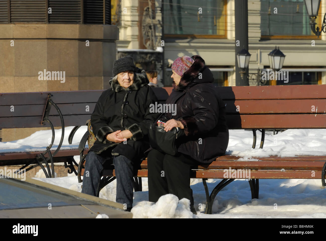 Two old ladies talk sitting on a bench Stock Photo - Alamy