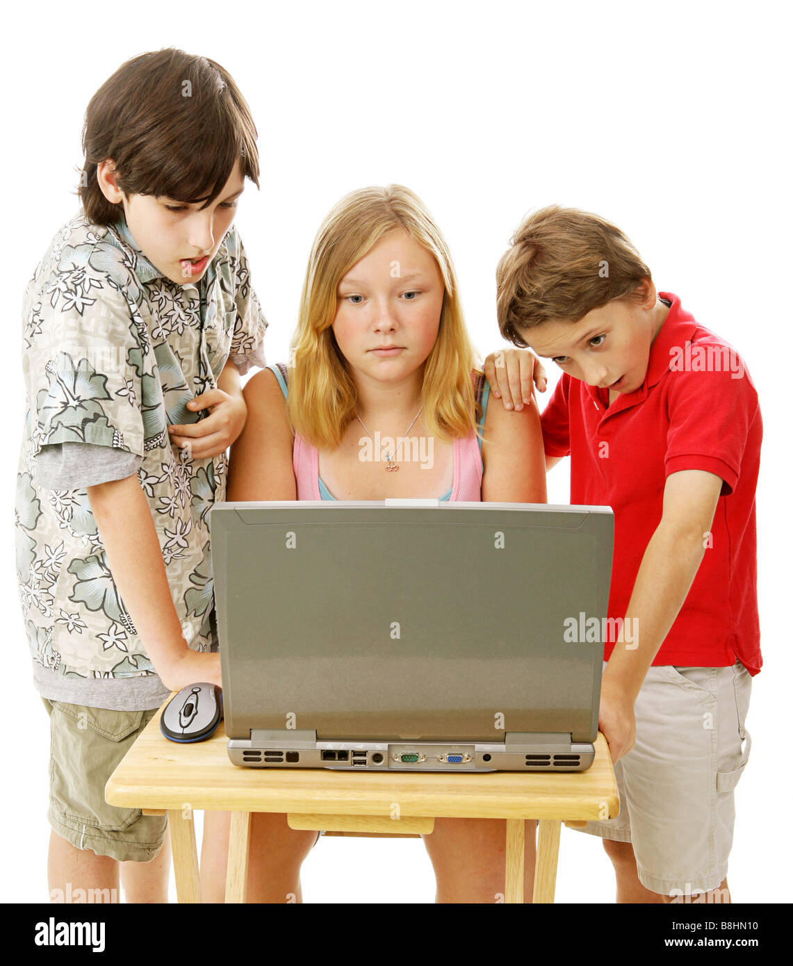 Three children on the computer with serious confused expressions ...
