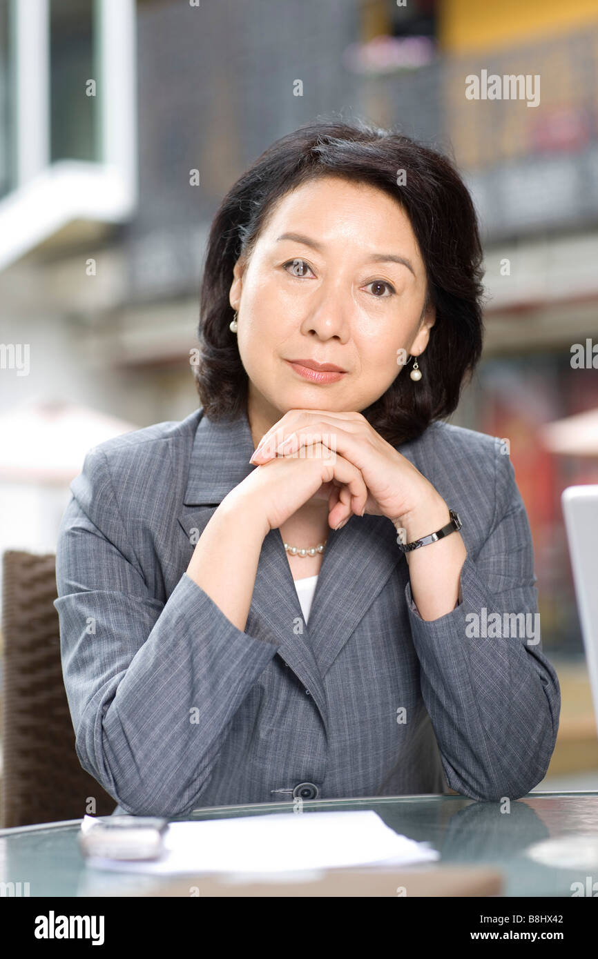 Businesswoman leaning on coffee table Stock Photo - Alamy