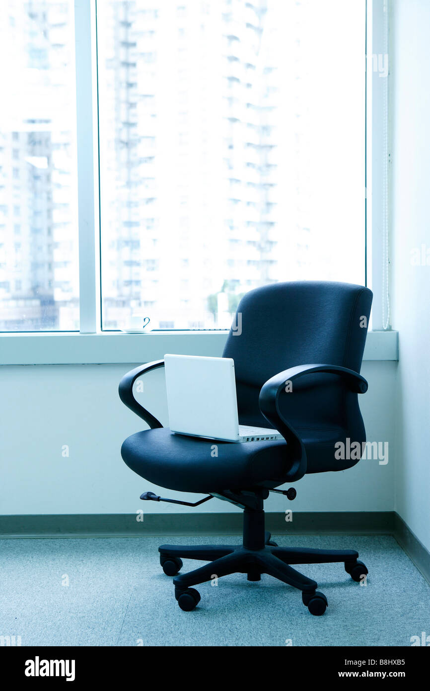 Laptop in chair at corner of office Stock Photo - Alamy