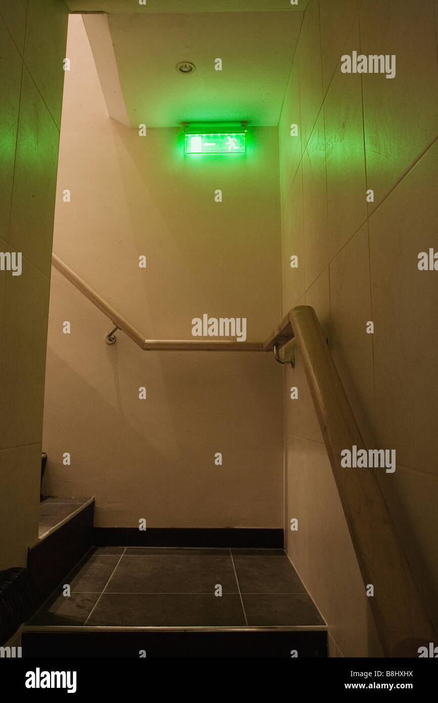 Illuminated exit sign on top of a flight of stairs Stock Photo - Alamy