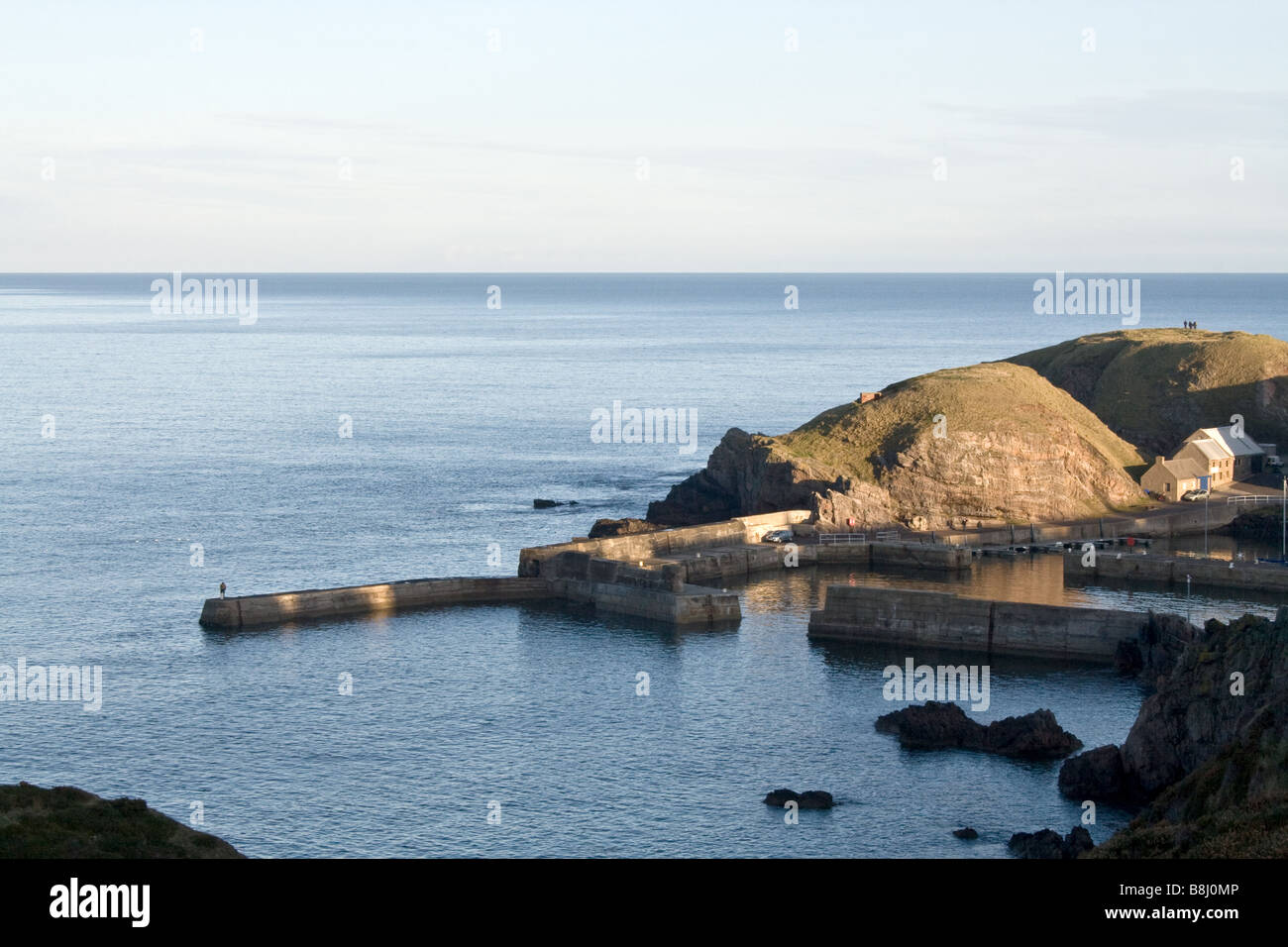 Small protected harbour by a calm sea in Portnockie, Scotland Stock ...