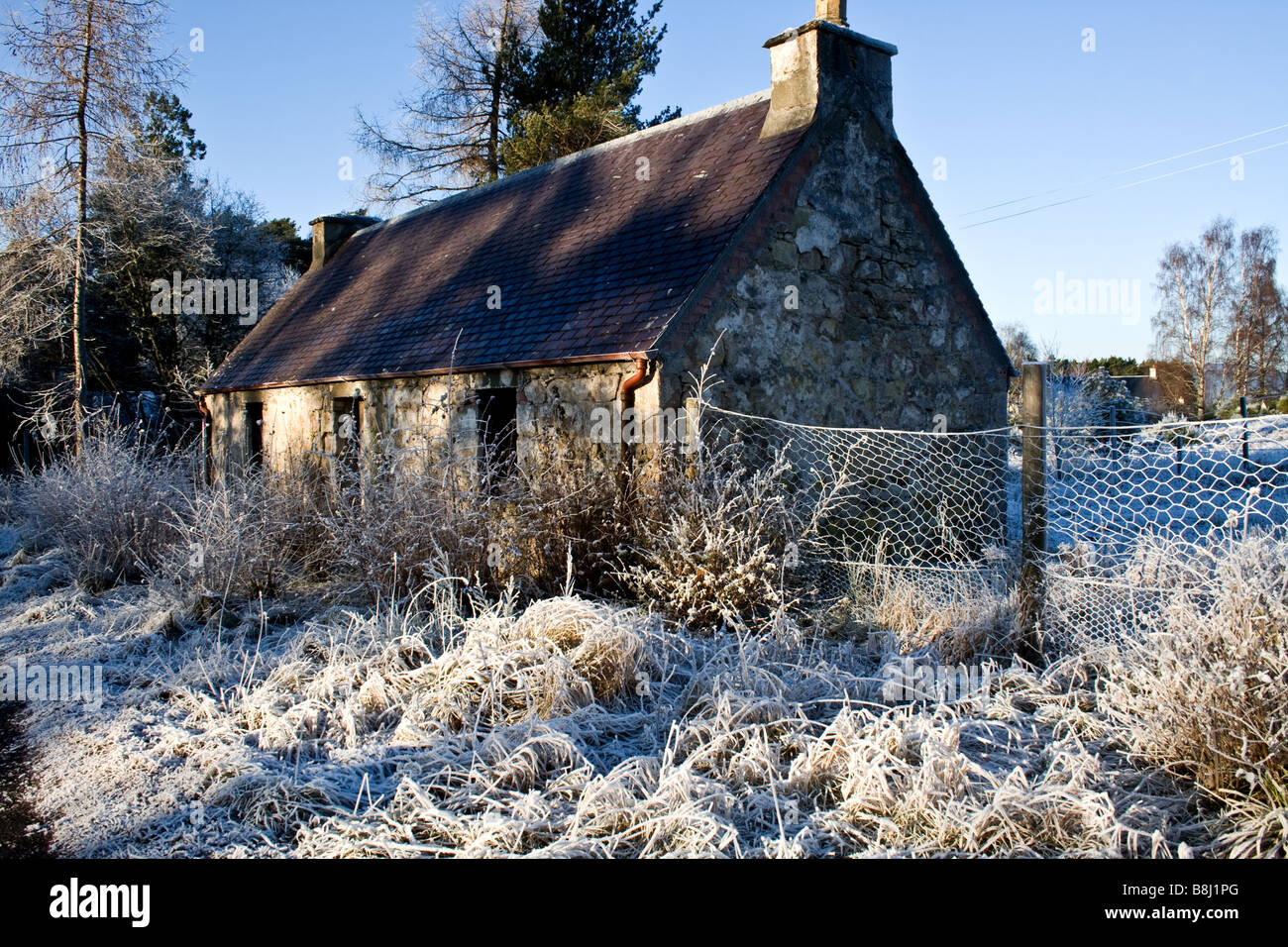 Old deserted stone cottage surrounded by hoar frost in the highlands of ...