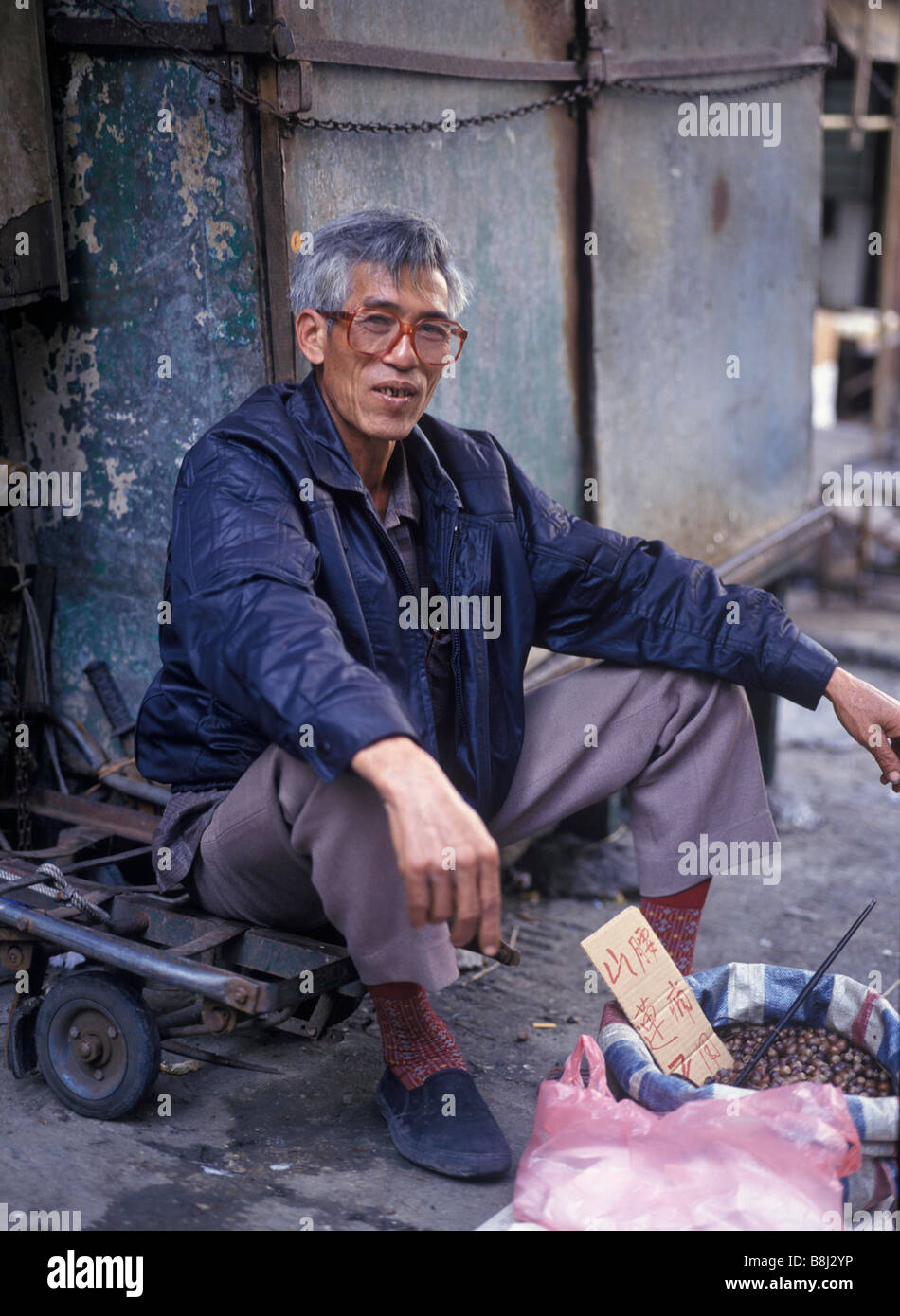 Chinese man selling nuts in Hong Kong Stock Photo - Alamy