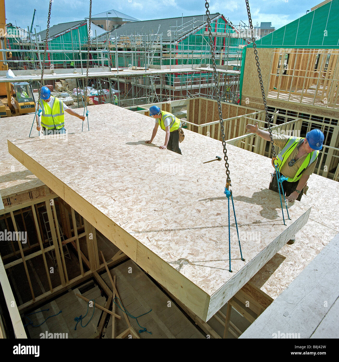 Contractors assembling a timber-framed structure - a fast, economical ...