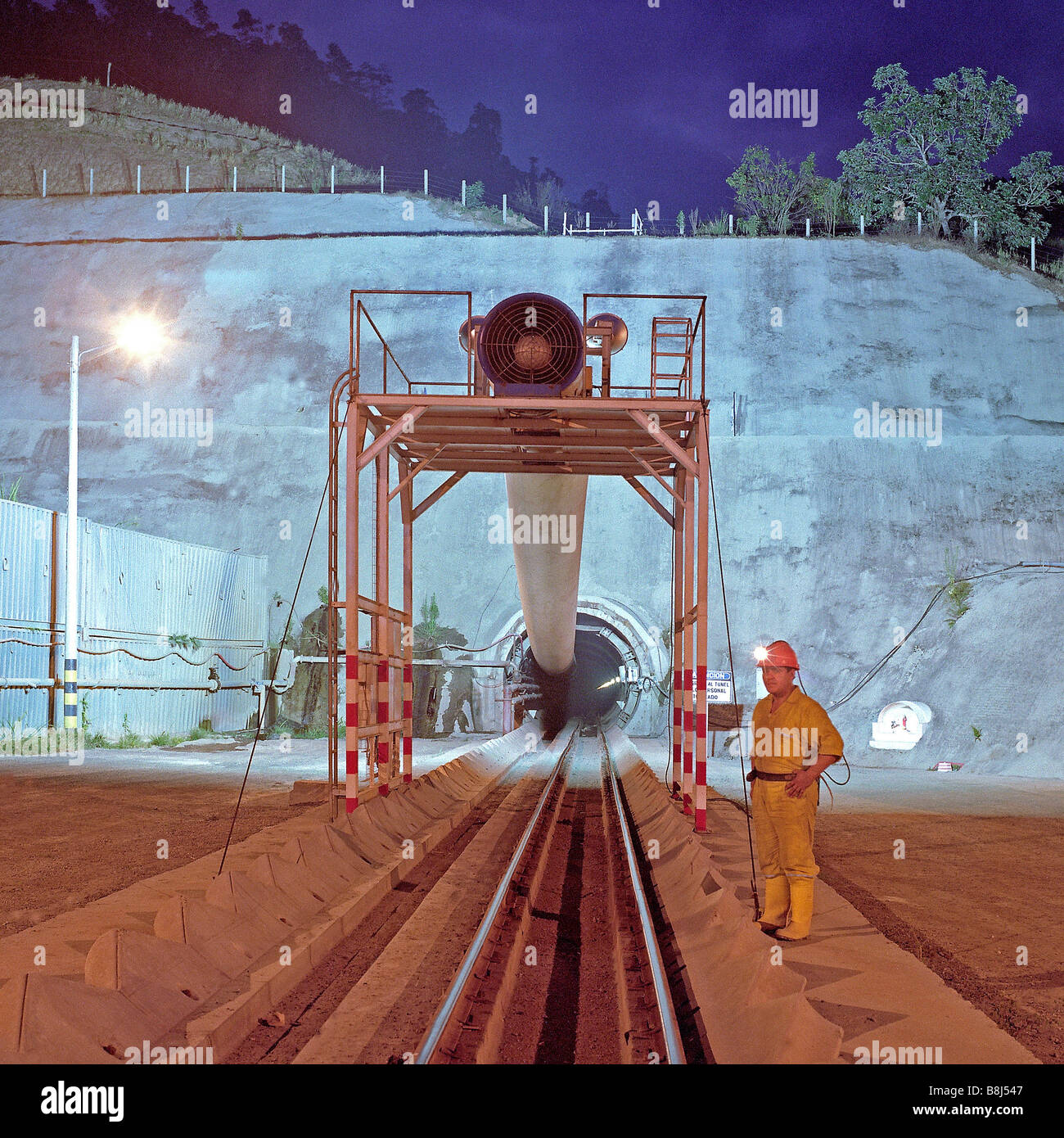 Portal at night with ventilation system and construction rail tracks of ...